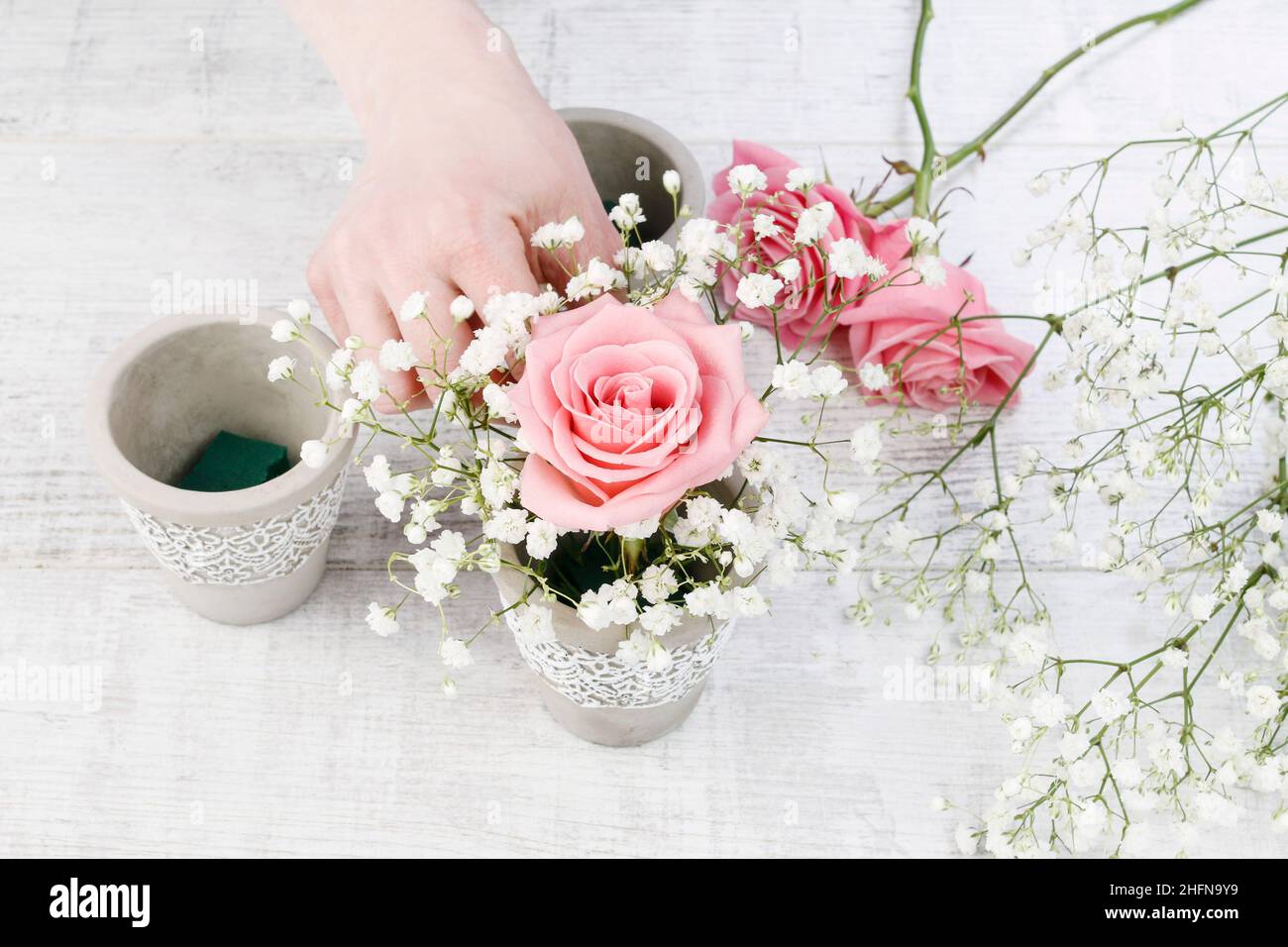 Florist at work: woman making decorations with pink roses and white ...