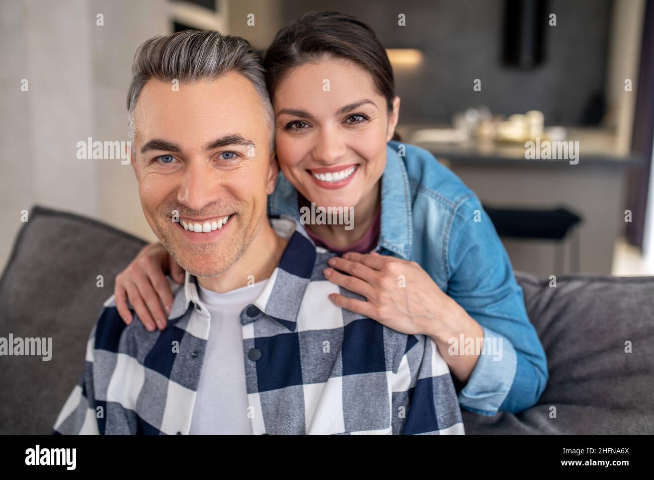 Woman touching shoulders of man smiling at camera Stock Photo - Alamy