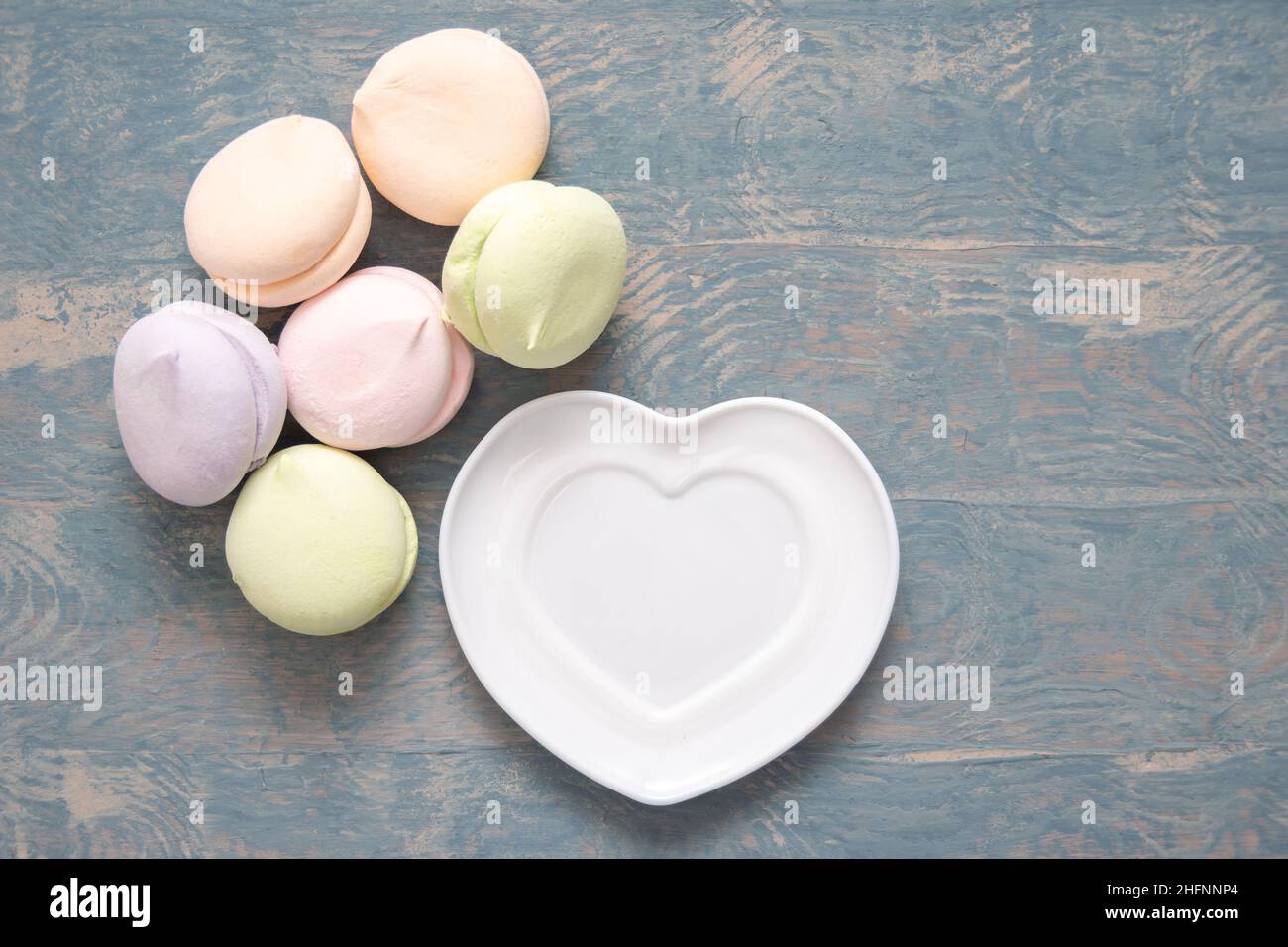 Round multi-colored marshmallows in a pile and a white plate in the ...