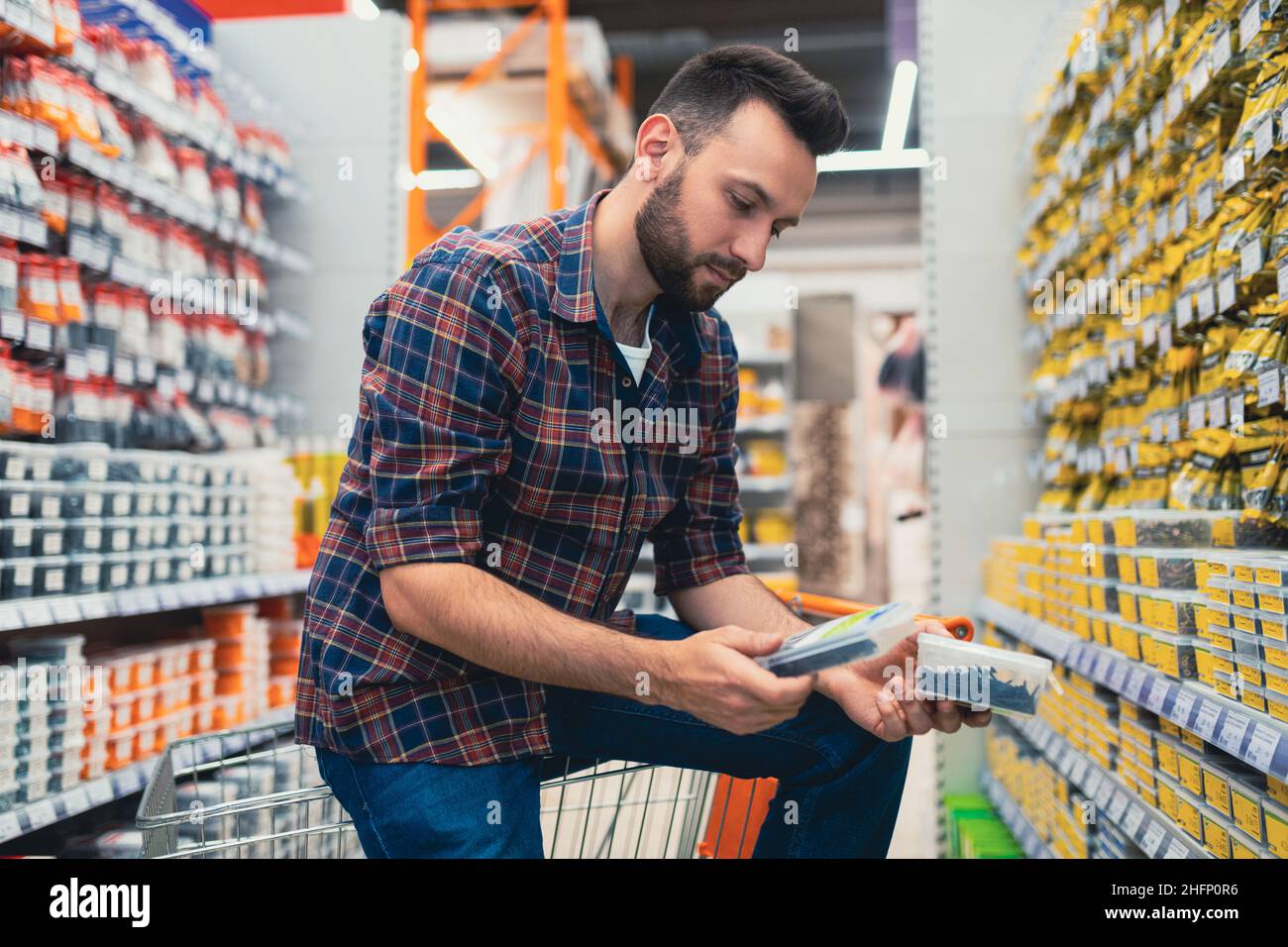 a buyer in a hardware store chooses screws and self-tapping screws for ...