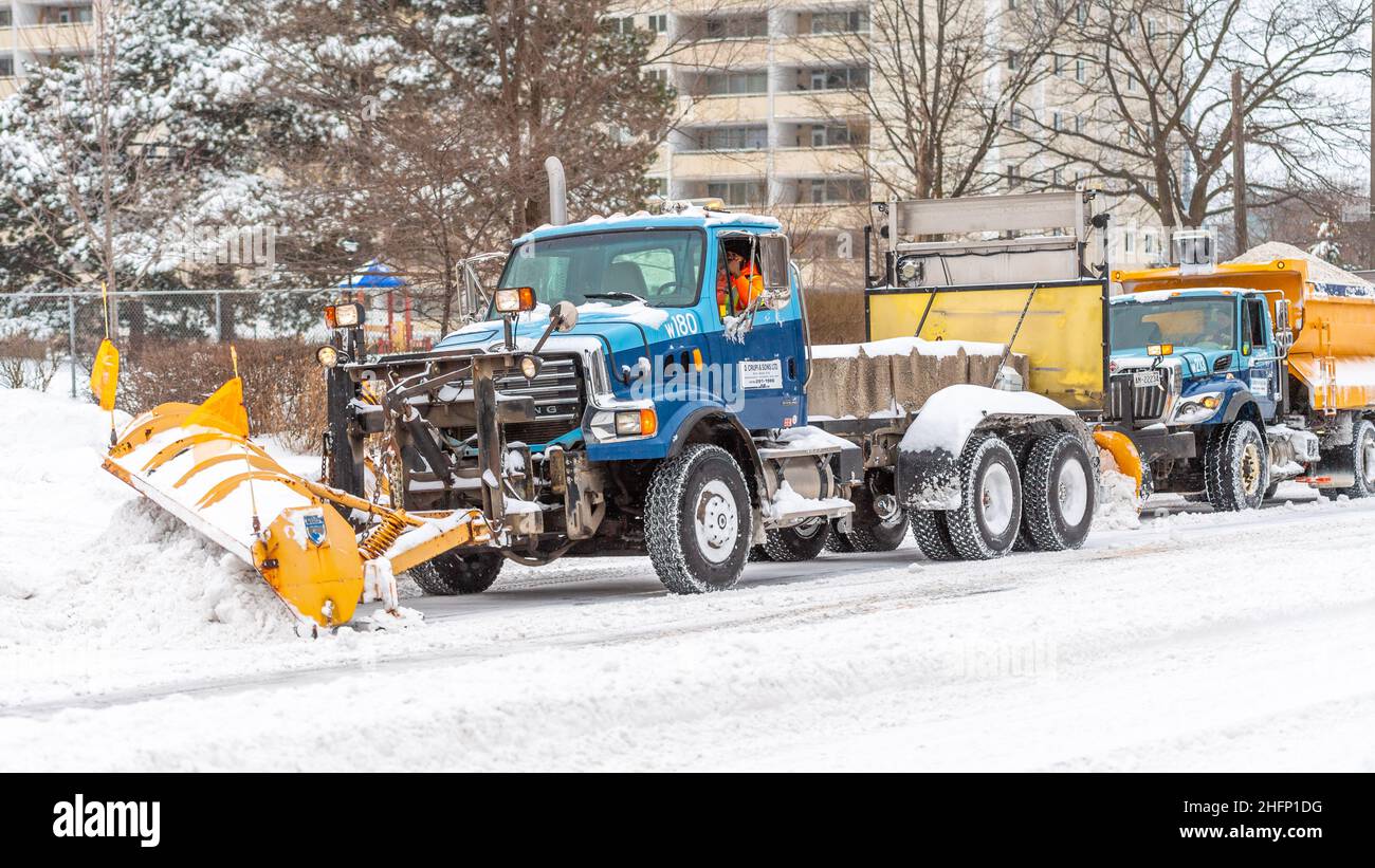 A crew of snow-clearing trucks drive in Victoria Park Avenue during a ...