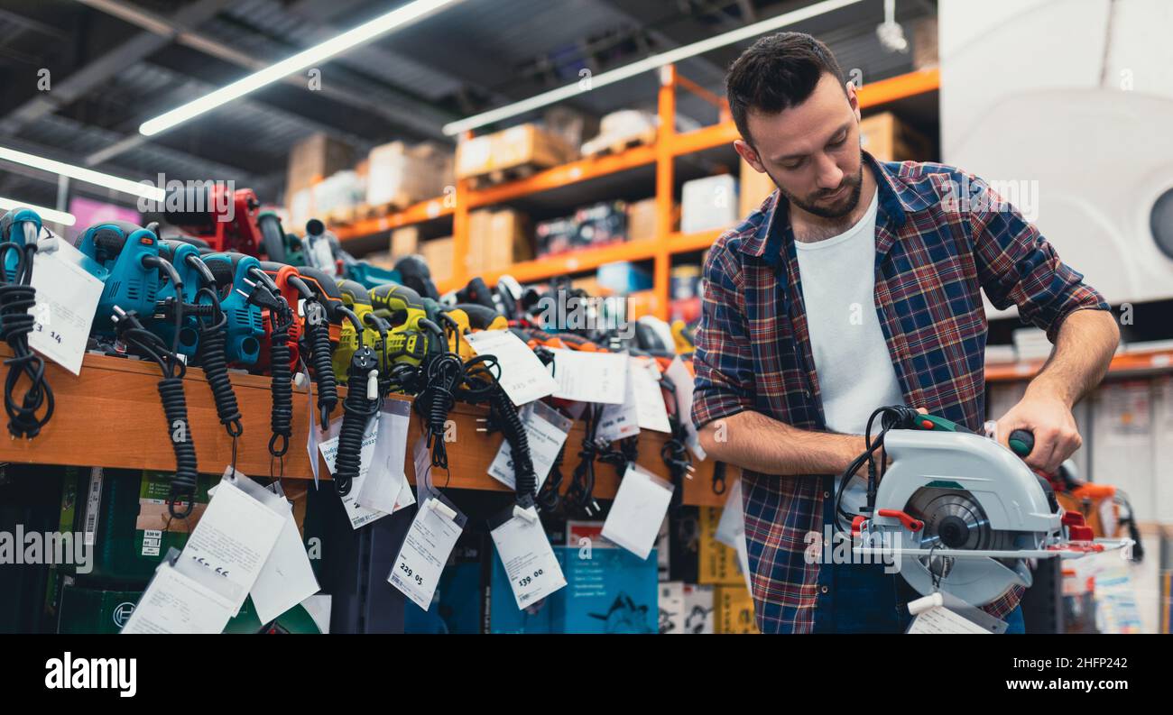 Young man chooses tool in hi-res stock photography and images - Alamy