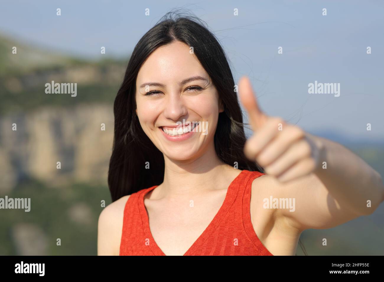 Front view portrait of a happy asian woman gesturing thumb up in the ...