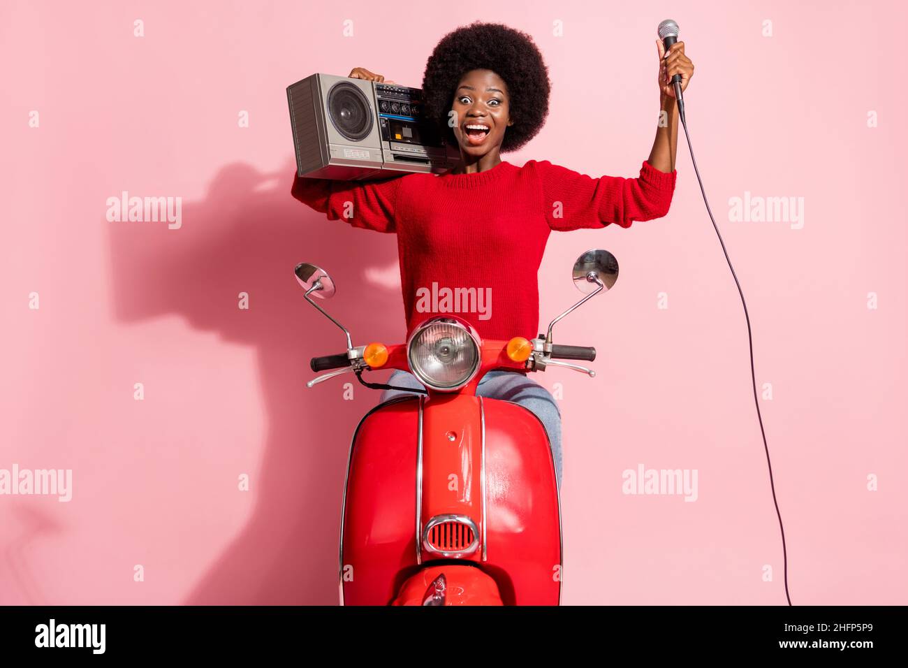 Portrait of crazy dark skin person sit on moped hold boombox mic open ...