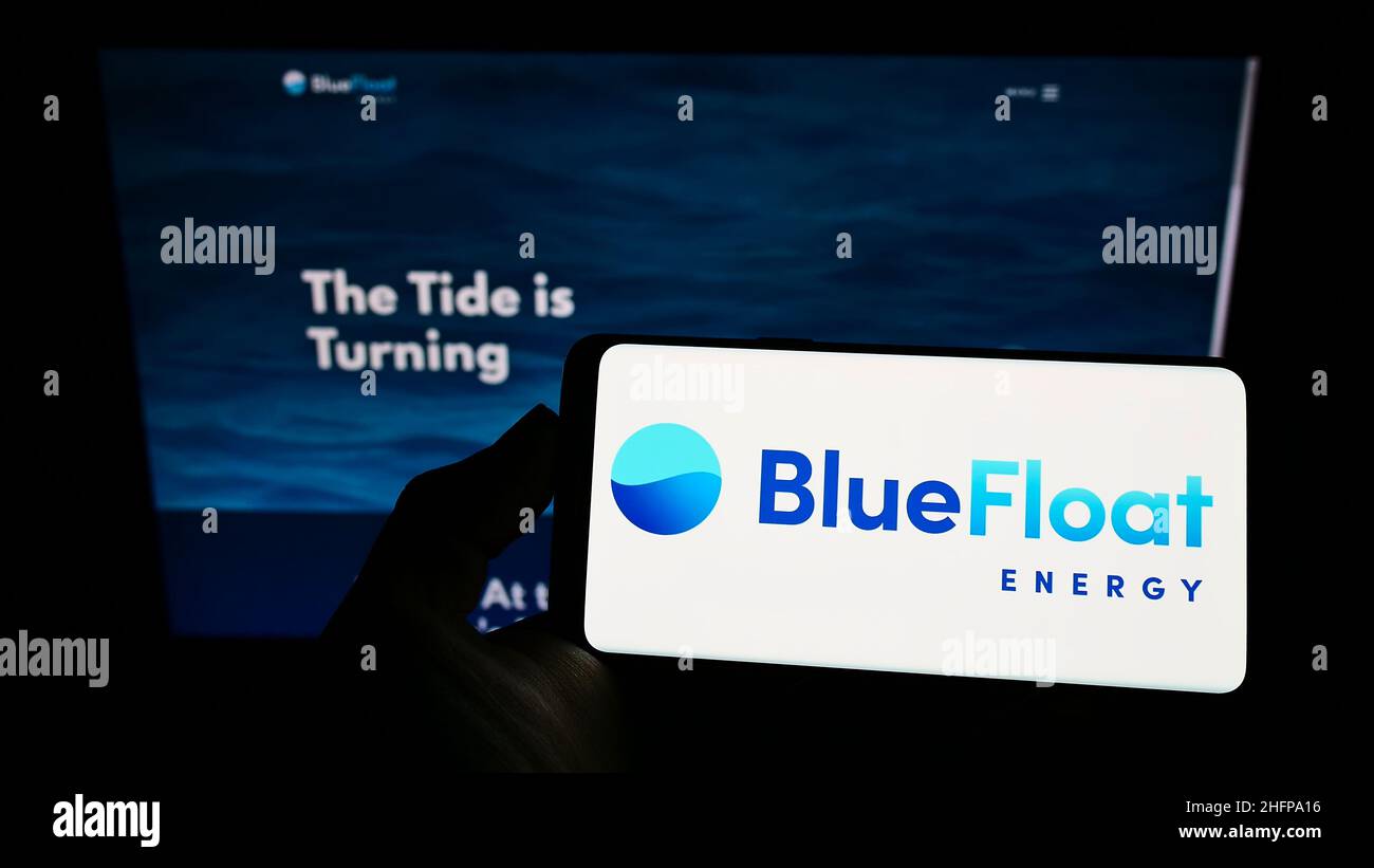 Person holding smartphone with logo of Spanish renewables company ...