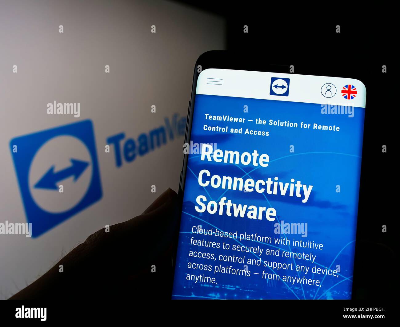 Person holding cellphone with website of German technology company ...