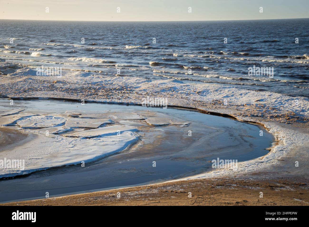 icy winter beach near the sea with frozen sand and ice blocks in the ...