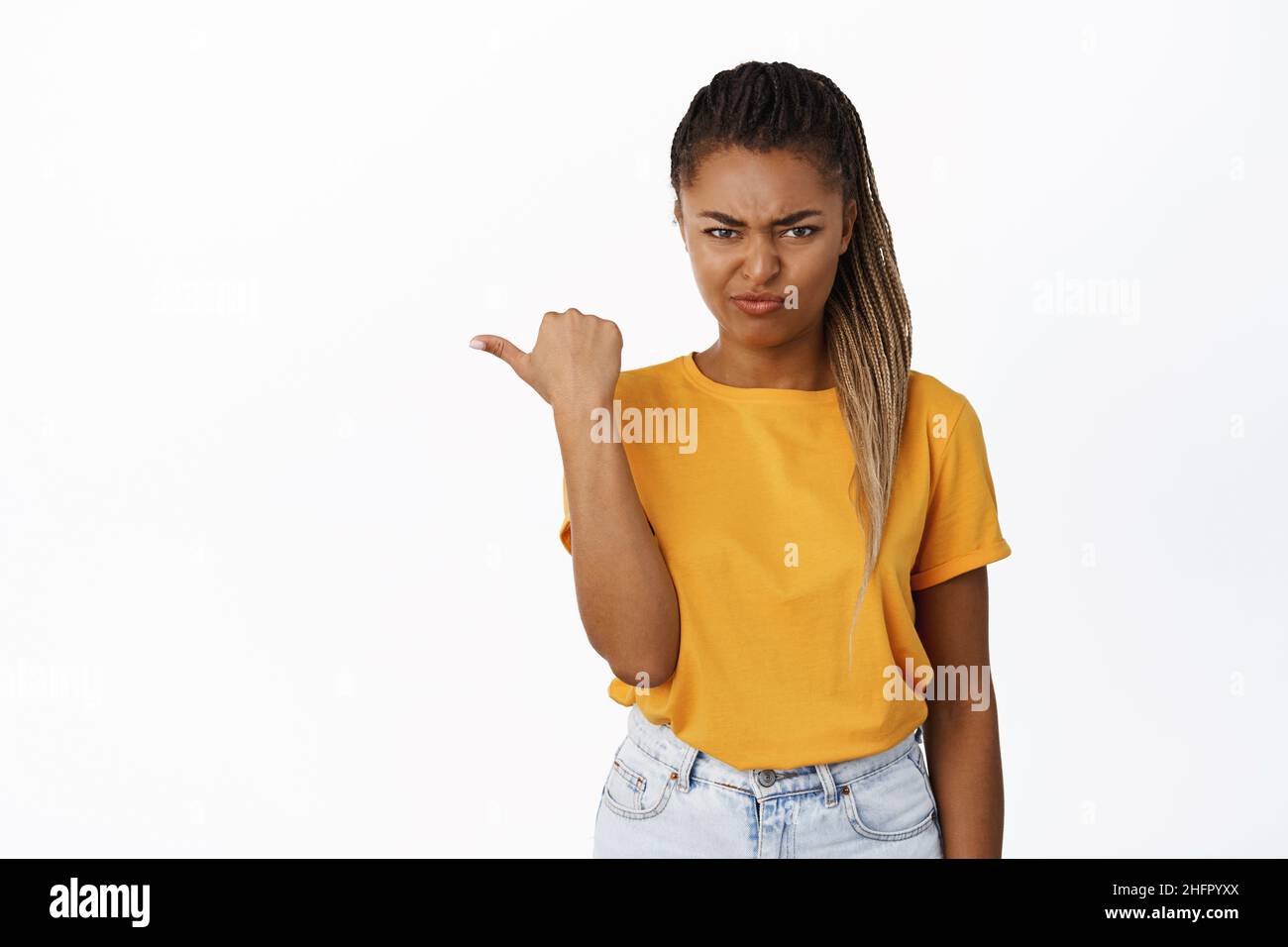 Angry and disappointed Black girl pointing left, dislike smth, express ...