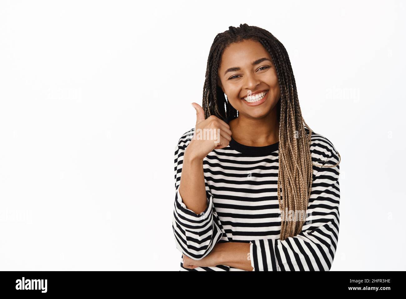 Portrait of happy beautiful black girl say yes, showing thumb up and ...