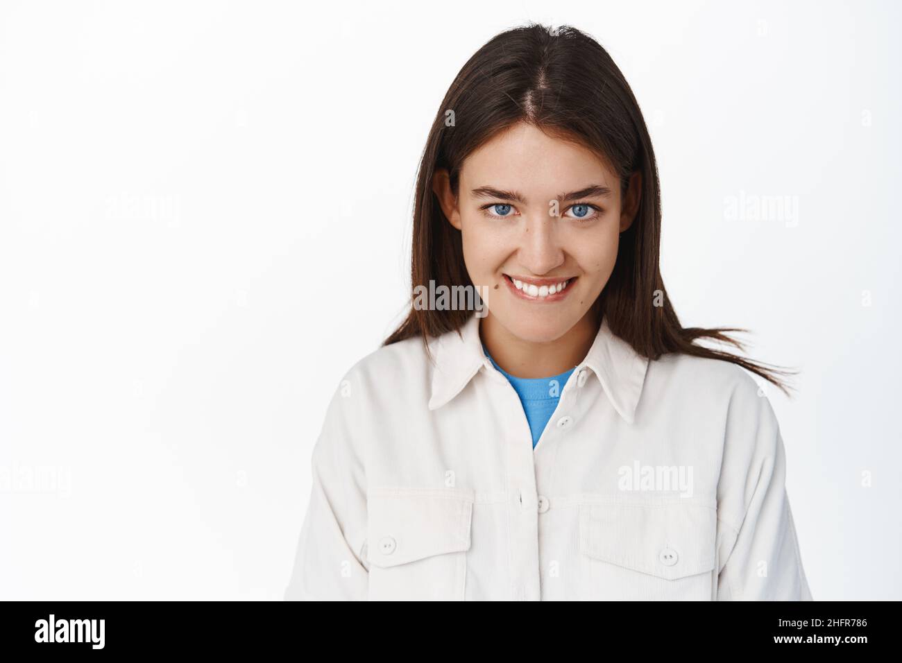Close up of excited smiling greedy girl, biting lip and looking with ...