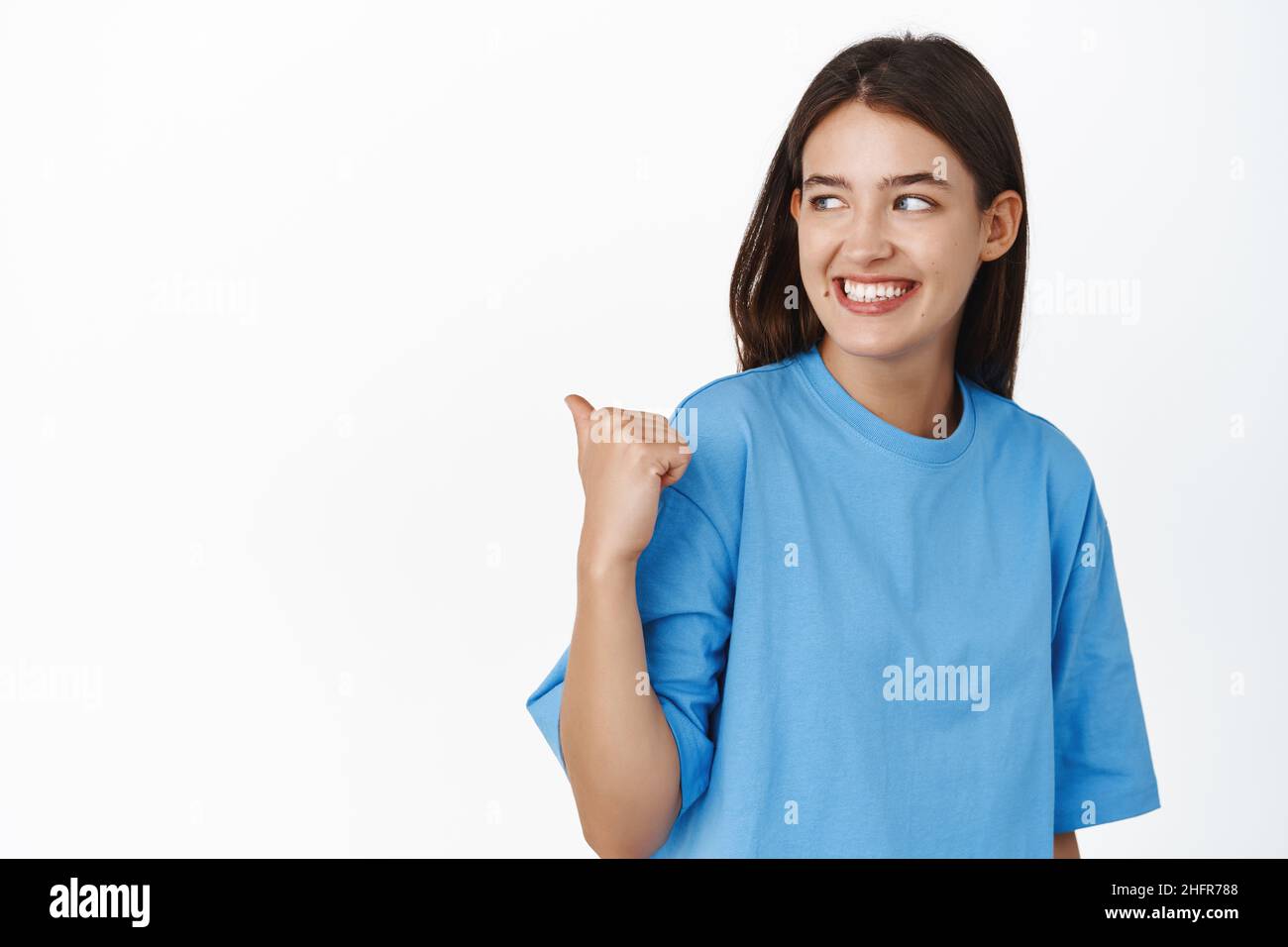 Portrait of attractive young woman in blue t-shirt, pointing and ...