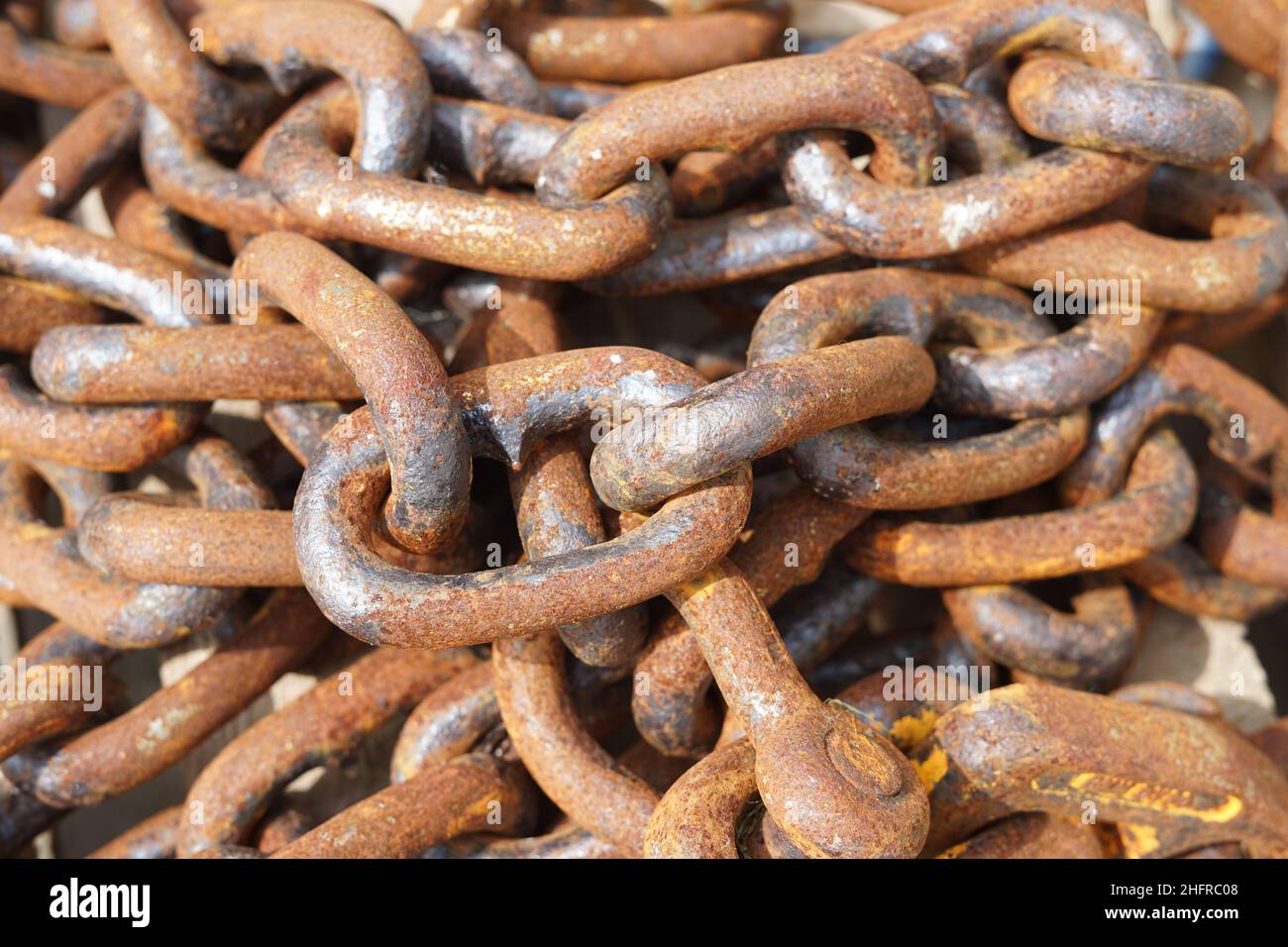 Rusty anchor chain, laying in loops at the pier Stock Photo - Alamy