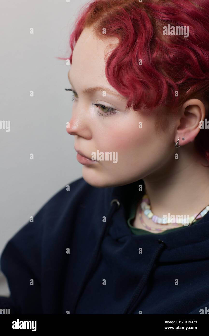 A beautician makes a puncture of the earlobe with a disposable device ...