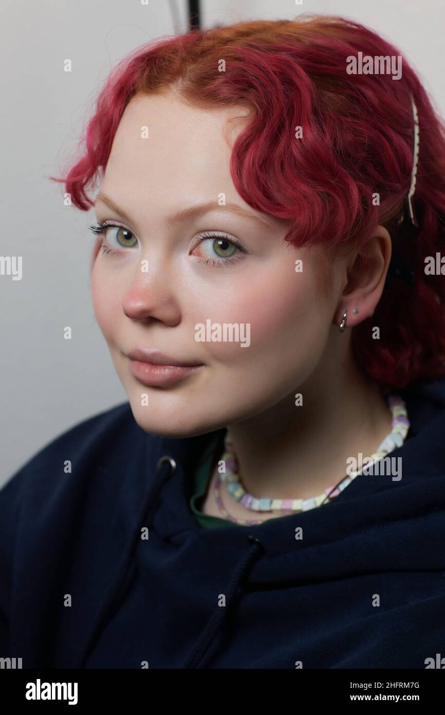 A beautician makes a puncture of the earlobe with a disposable device ...