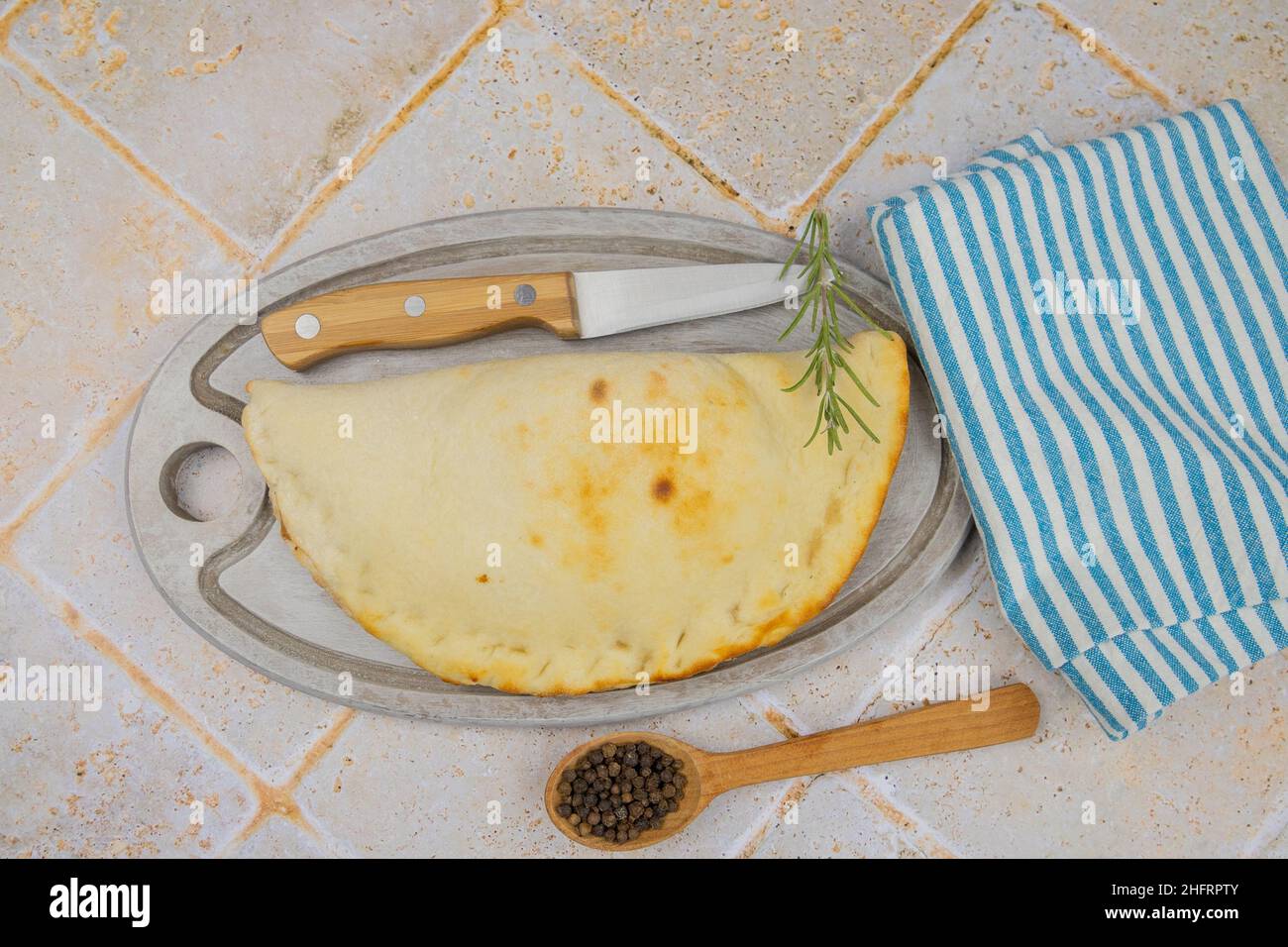 cooked calzone on a wooden board on a table Stock Photo - Alamy