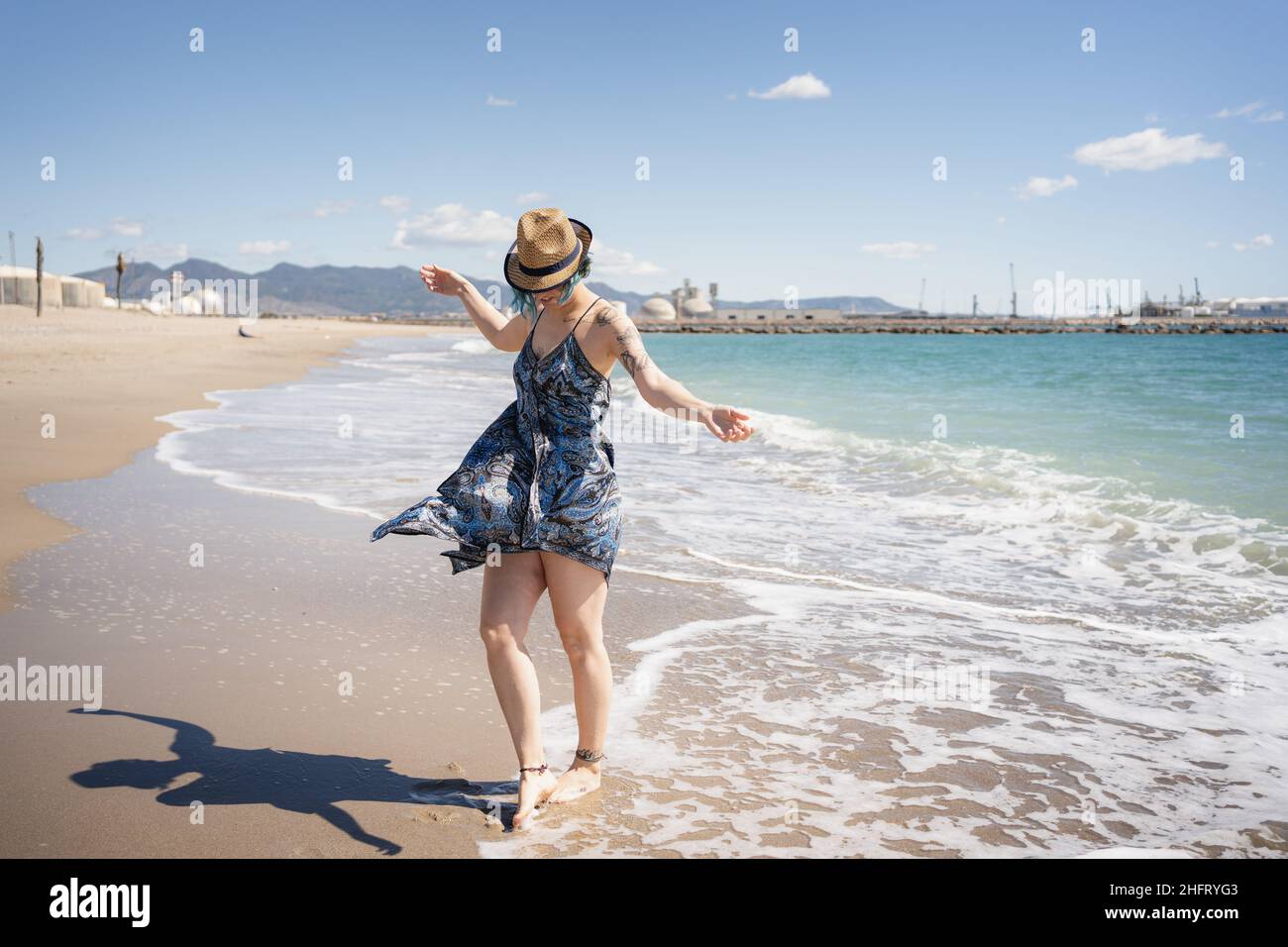 Happy woman dancing free on the beach with hat Stock Photo - Alamy