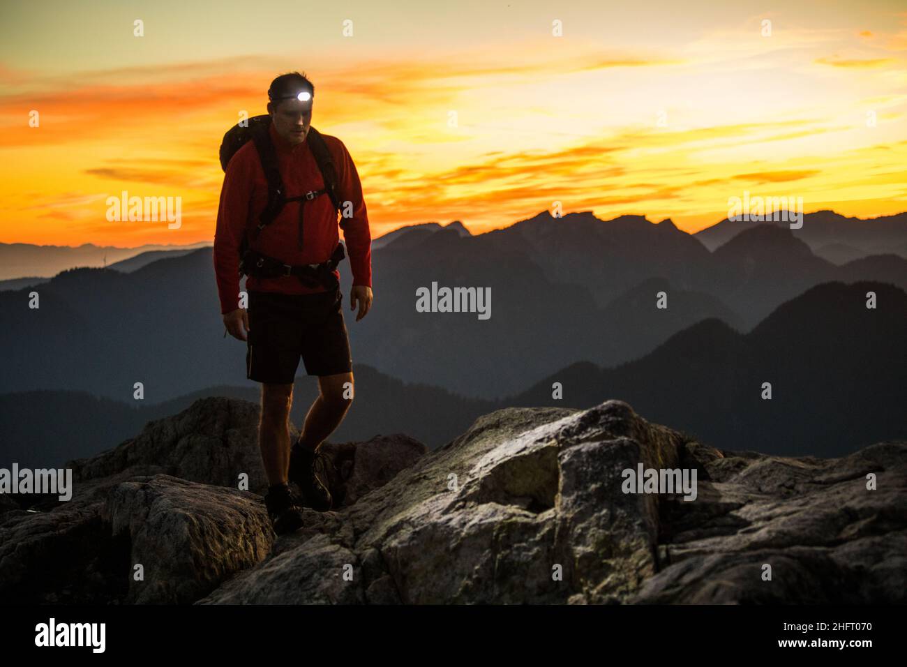 Backpacker hiking at night, using headlamp on rocky terrain Stock Photo ...