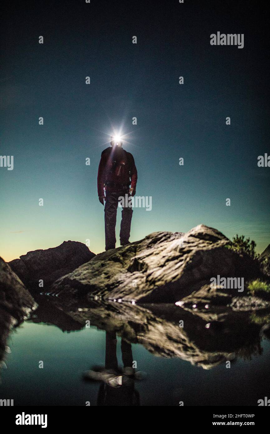 Hiker navigating rocky terrain at night using headlamp Stock Photo - Alamy