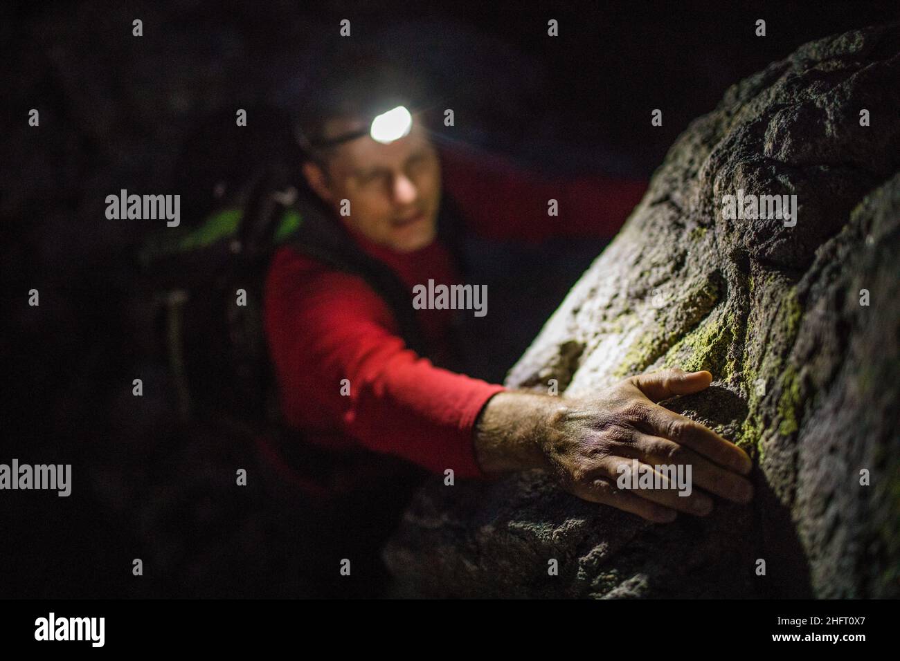 Rock climber finds a hand hold while climbing at night Stock Photo - Alamy