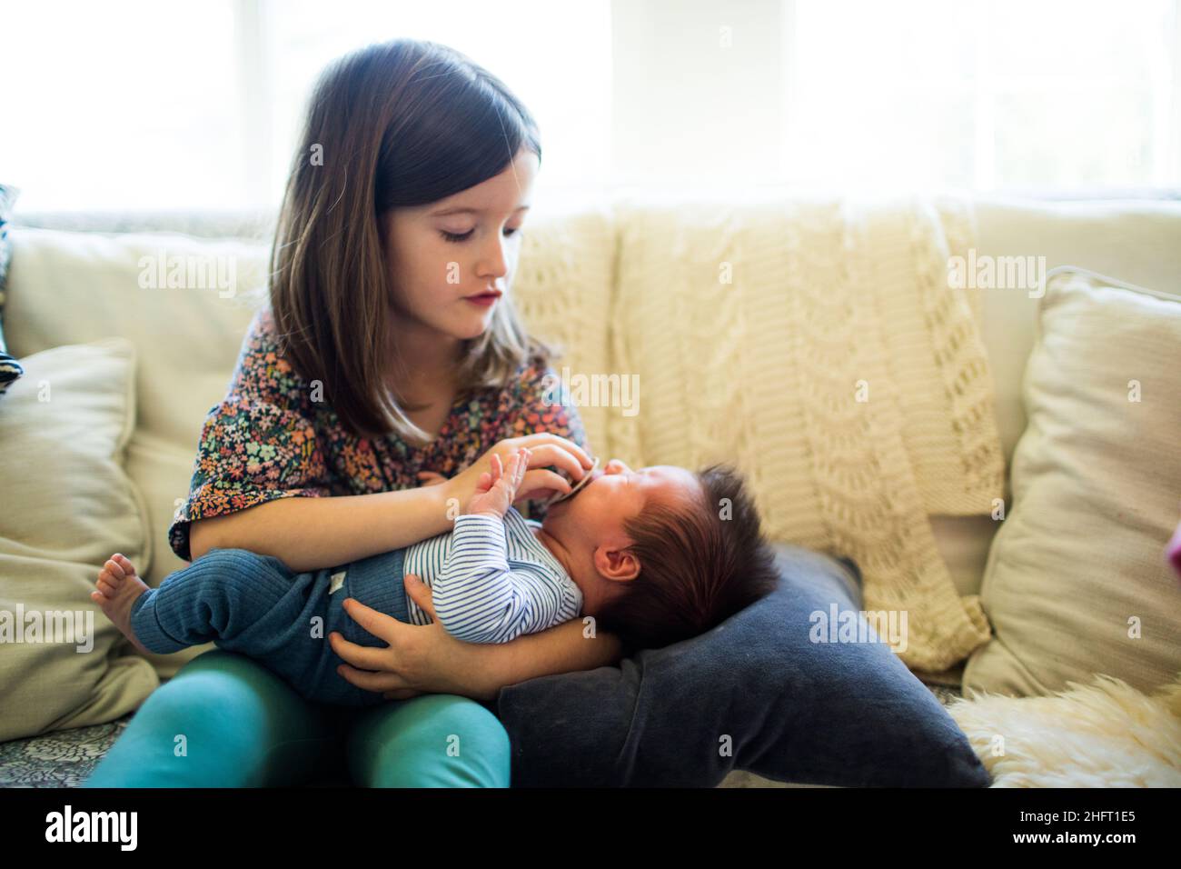 Big sister caring for her newborn baby brother Stock Photo - Alamy