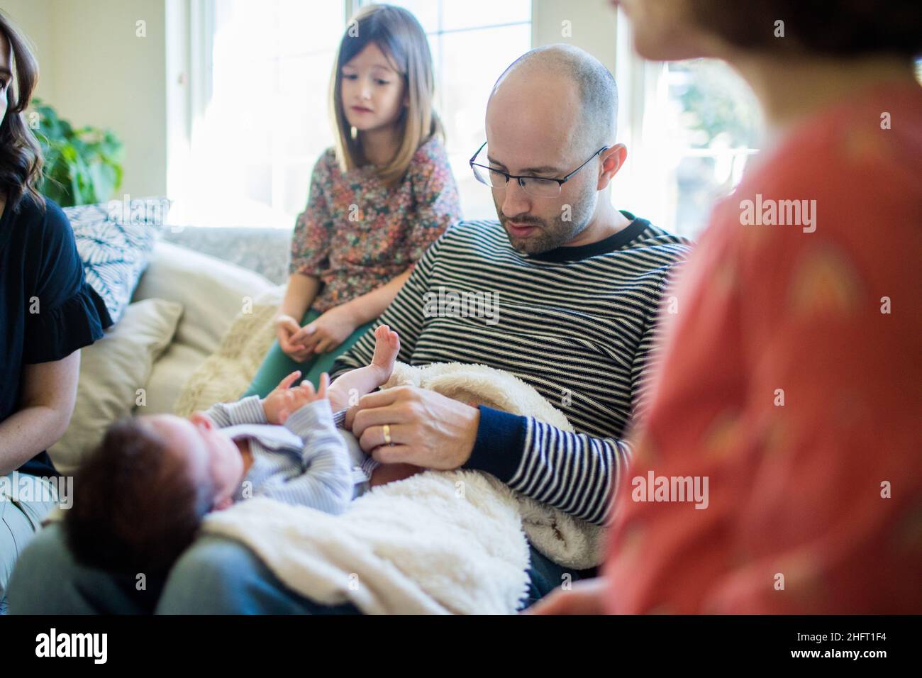 Father parenting newborn, older siblings at home Stock Photo - Alamy
