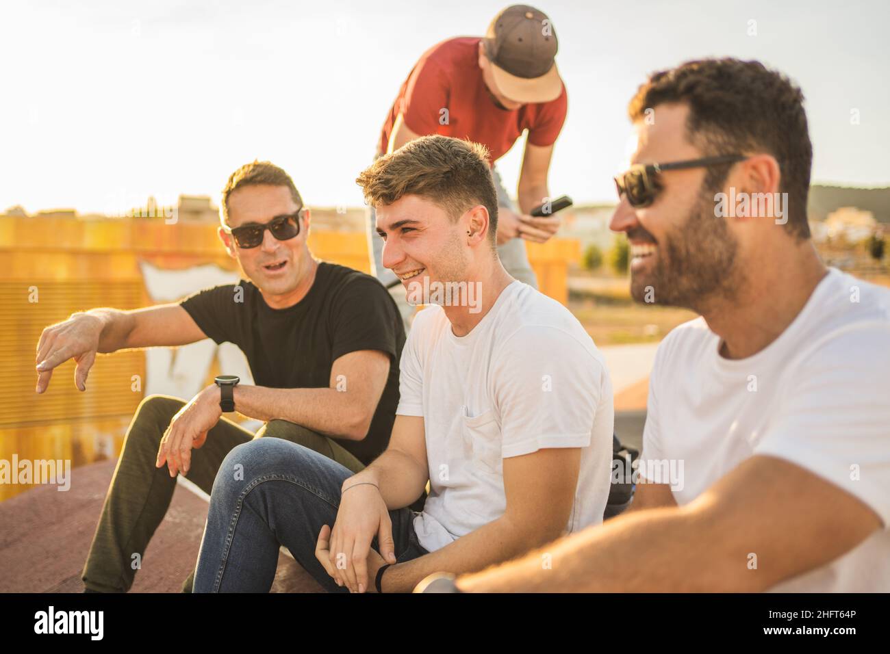 Friends talking animated at sunset in a skate park Stock Photo - Alamy