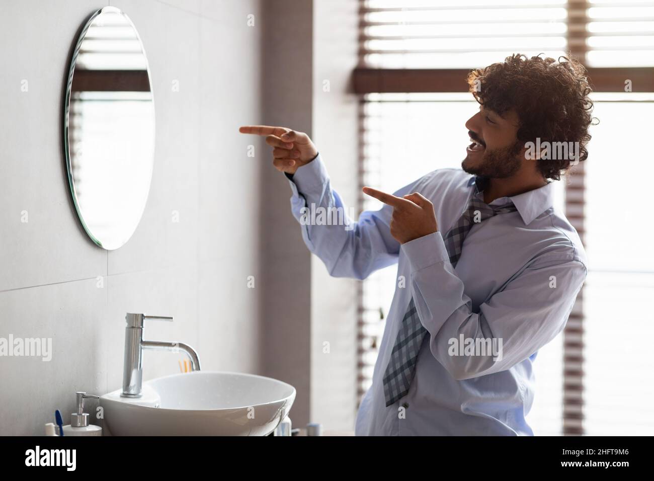 Champion's morning concept. Young indian businessman in shirt pointing ...