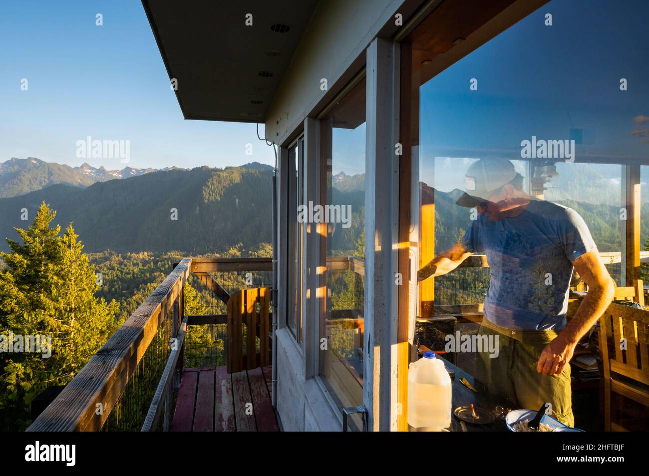 Male making food inside Heybrook Fire Lookout Tower in the mountains ...