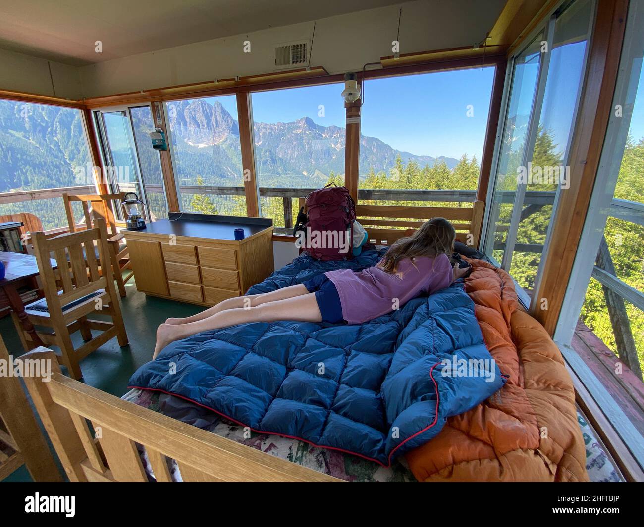 Female relaxing inside a fire lookout tower in the Cascade Mountains ...