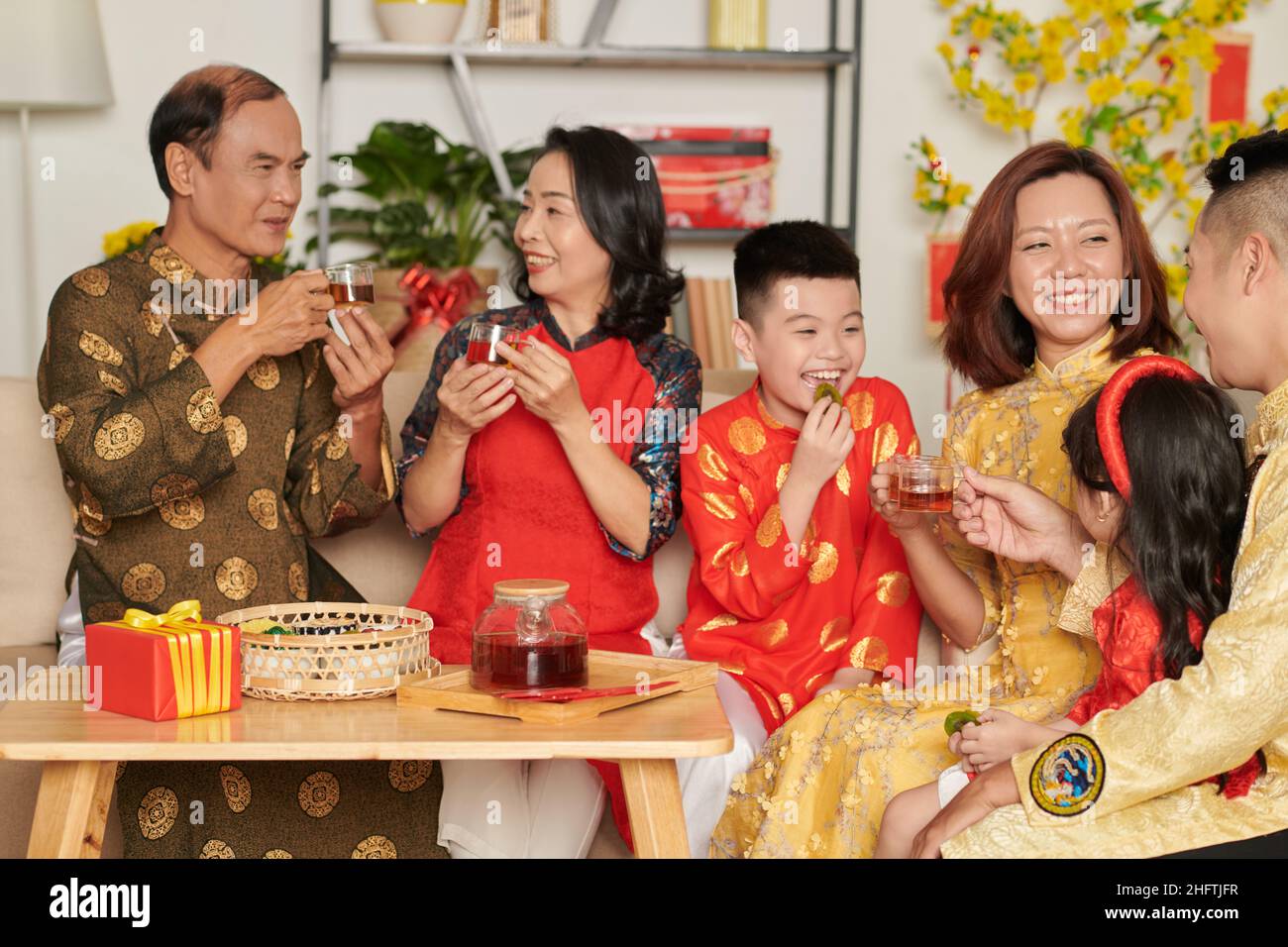 Big happy family enjoying tea with candied fruits and sweets when ...