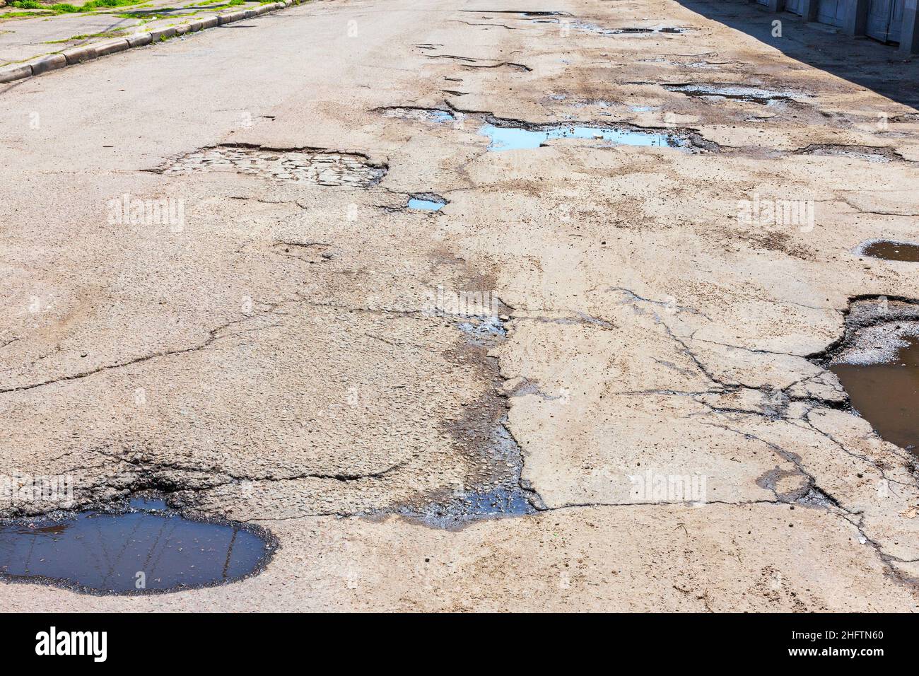 A road damaged by rain and snow, that is in need of maintenance. Broken ...