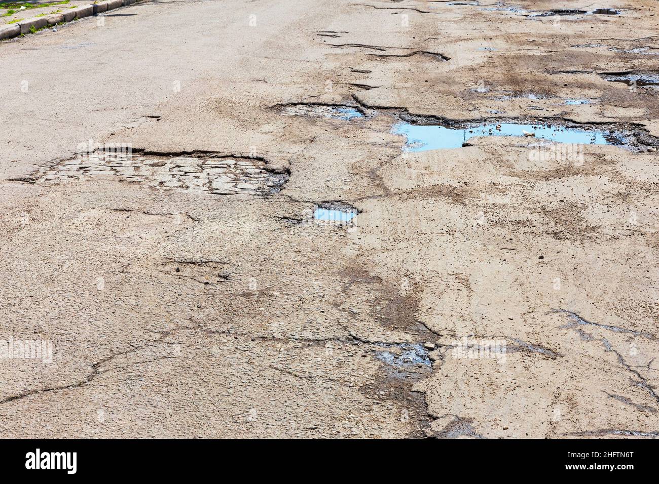 A road damaged by rain and snow, that is in need of maintenance. Broken ...