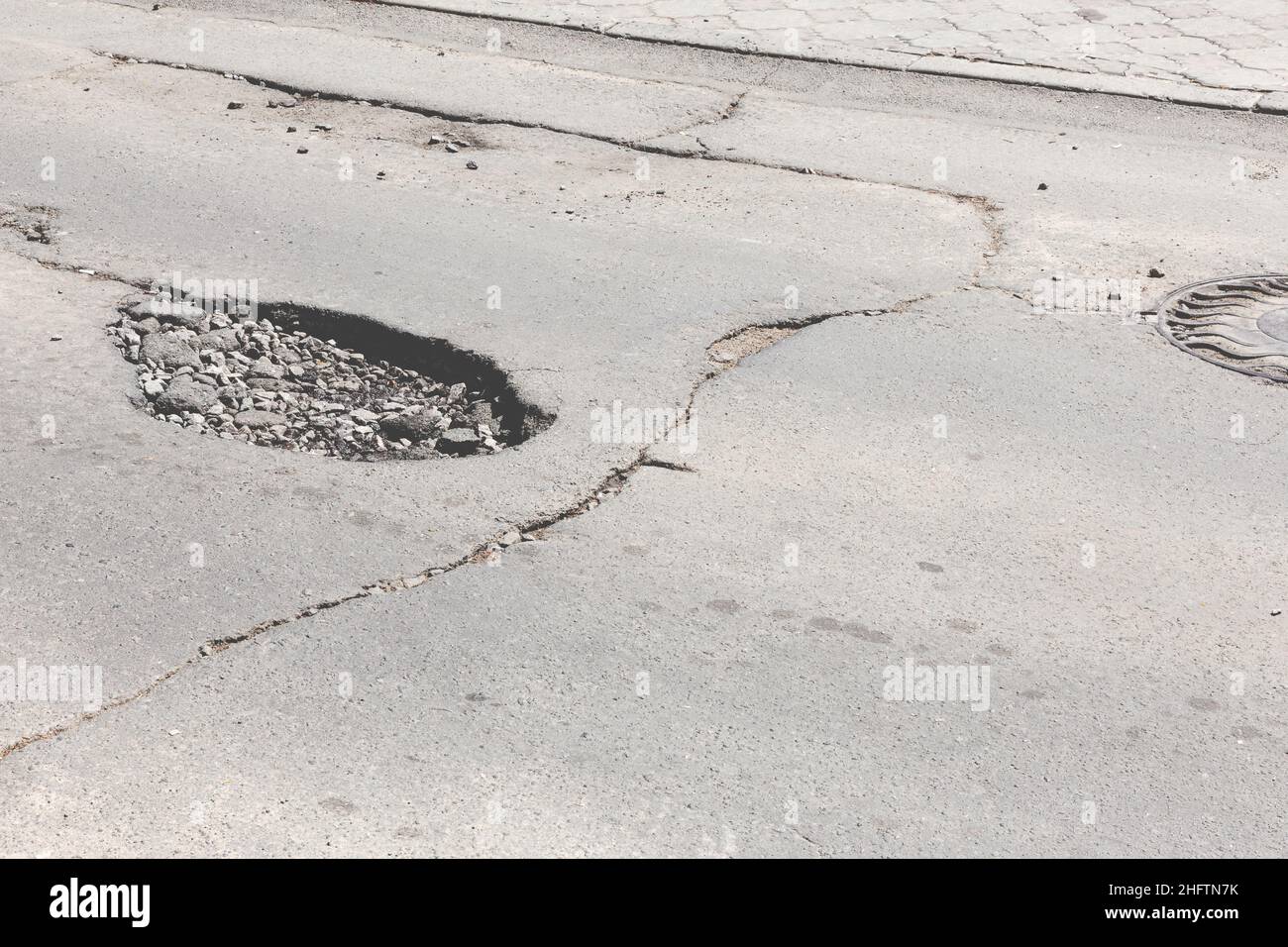 A road damaged by rain and snow, that is in need of maintenance. Broken ...