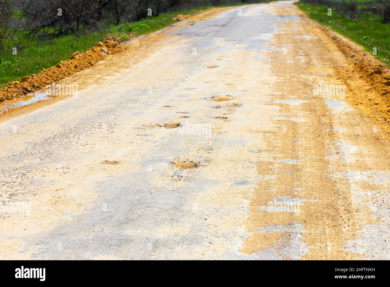 A road damaged by rain and snow, that is in need of maintenance. Broken ...