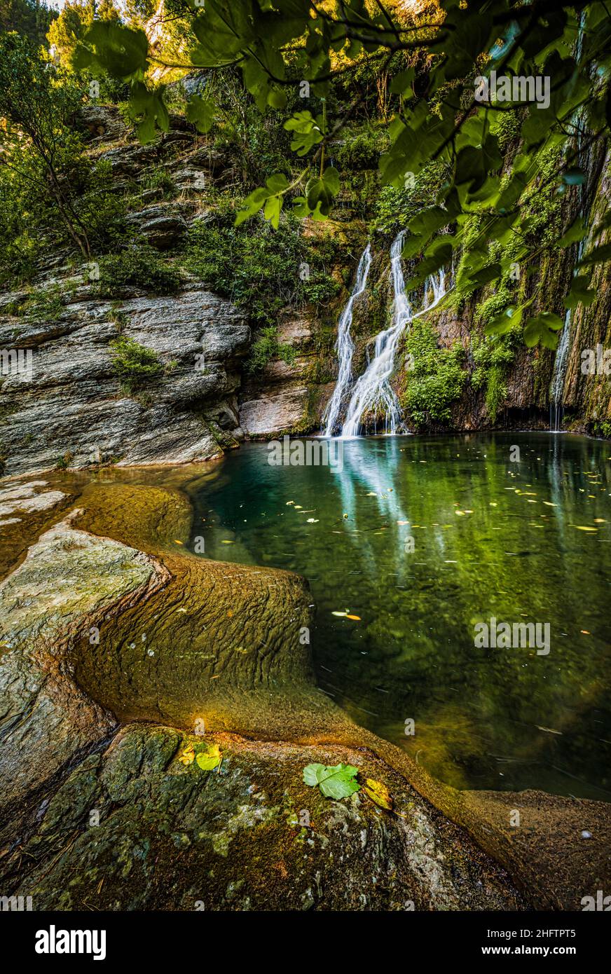 Natural swimming pool carved into the rock with a spring water cascade ...
