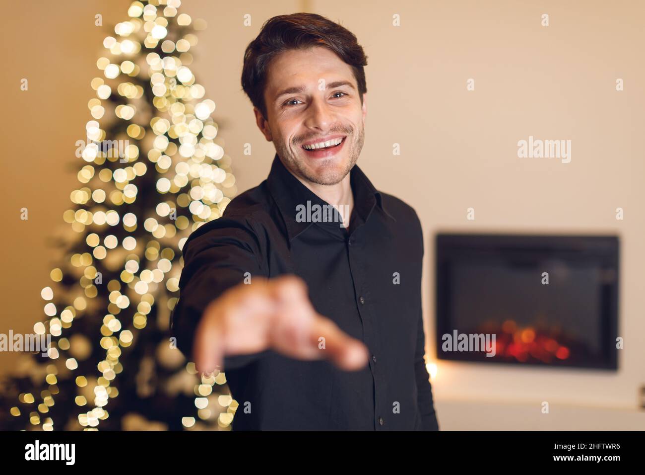 Excited young man reaching hand to camera Stock Photo - Alamy