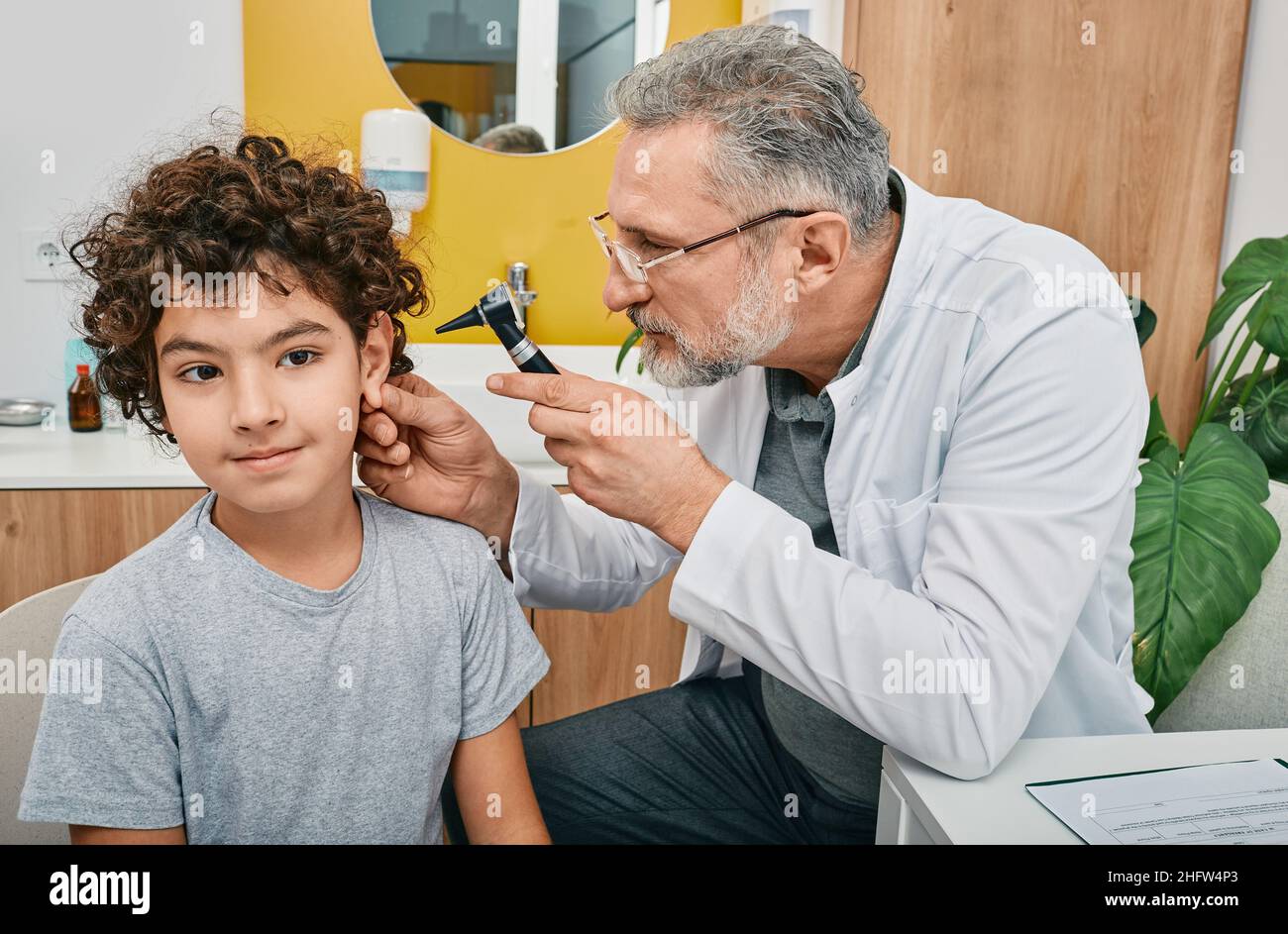 Otoscopy and hearing check-up for boy at audiology office. Audiologist ...
