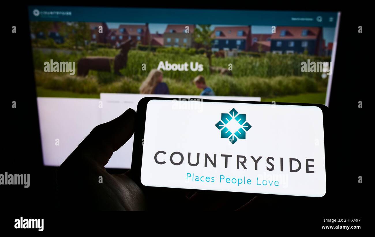 Person holding cellphone with logo of British company Countryside ...
