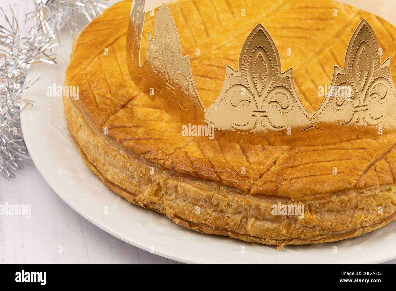 galette des rois on a table with a crown and a garland Stock Photo - Alamy