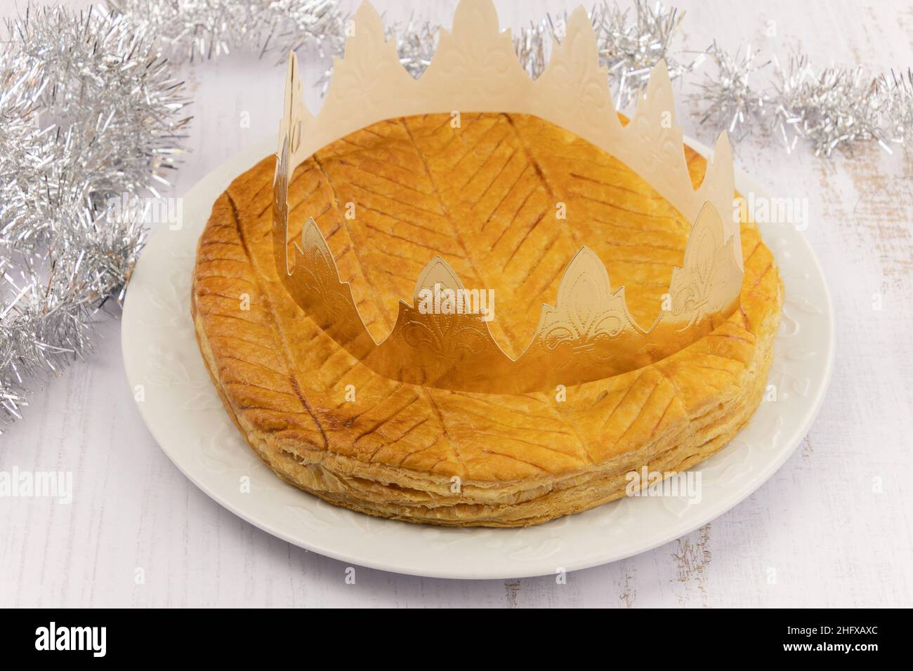 galette des rois on a table with a crown and a garland Stock Photo - Alamy