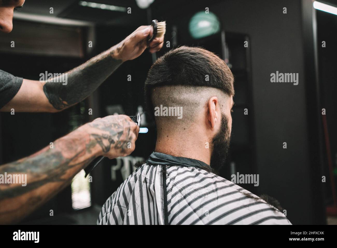 Young man client at barbershop getting haircut hipster trim hair ...