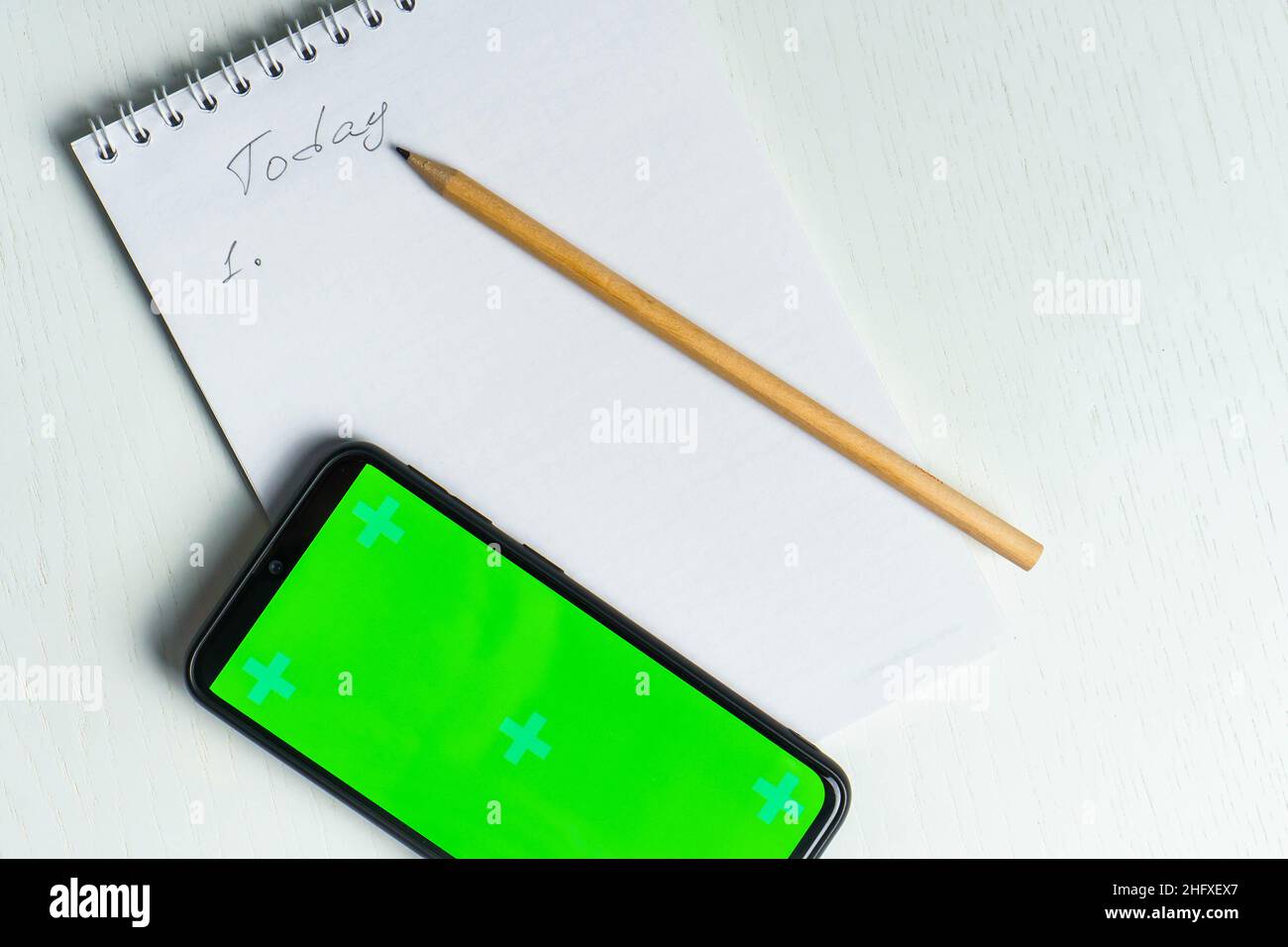 White notepad with inscription today, smartphone green screen mockup ...