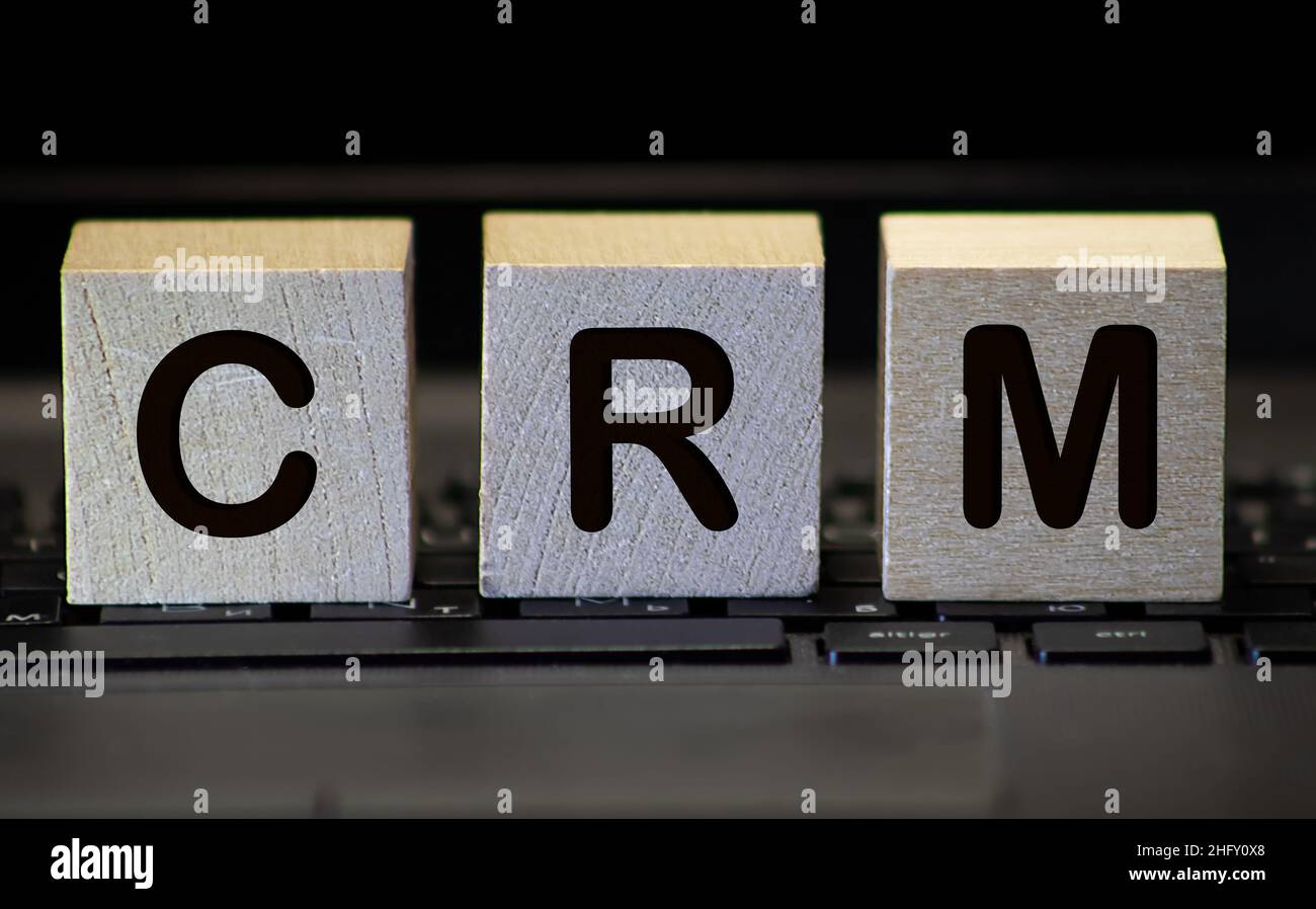 CRM Customer Relationship Marketing written on a wooden cube in front ...