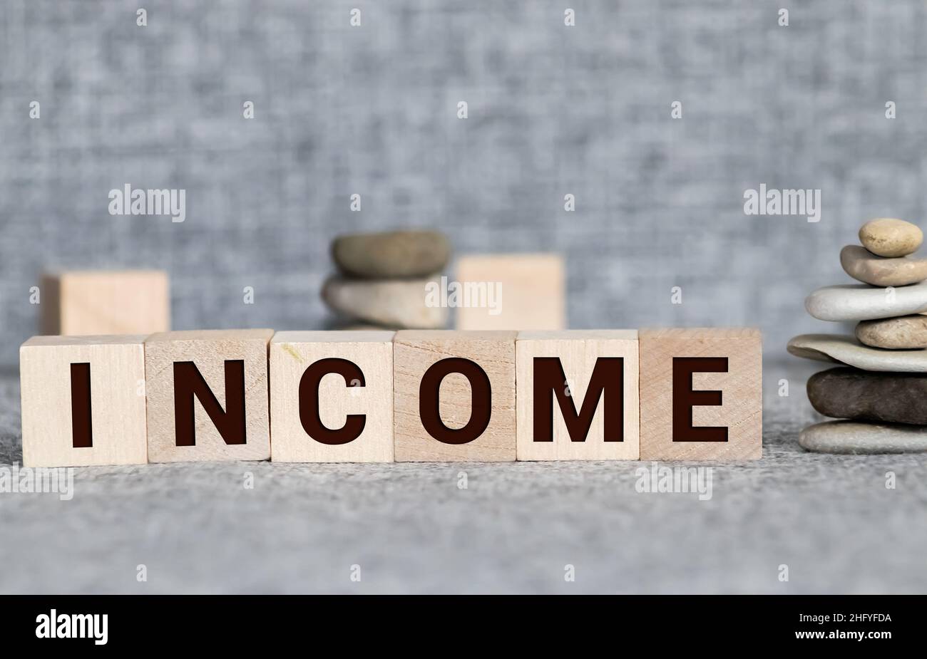INCOME text written on wooden block with stacked coins isolated on ...