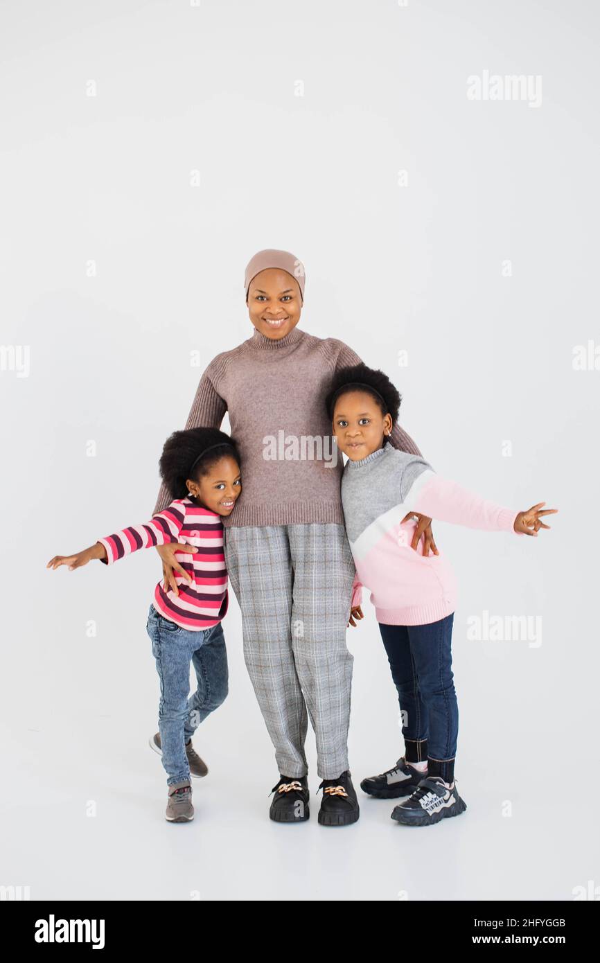 Full length portrait of happy african muslim woman in hijab embracing ...