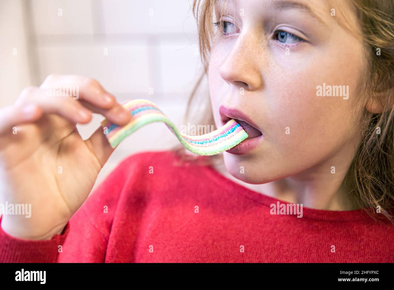 Close up, little girl eating gummy candy Stock Photo - Alamy