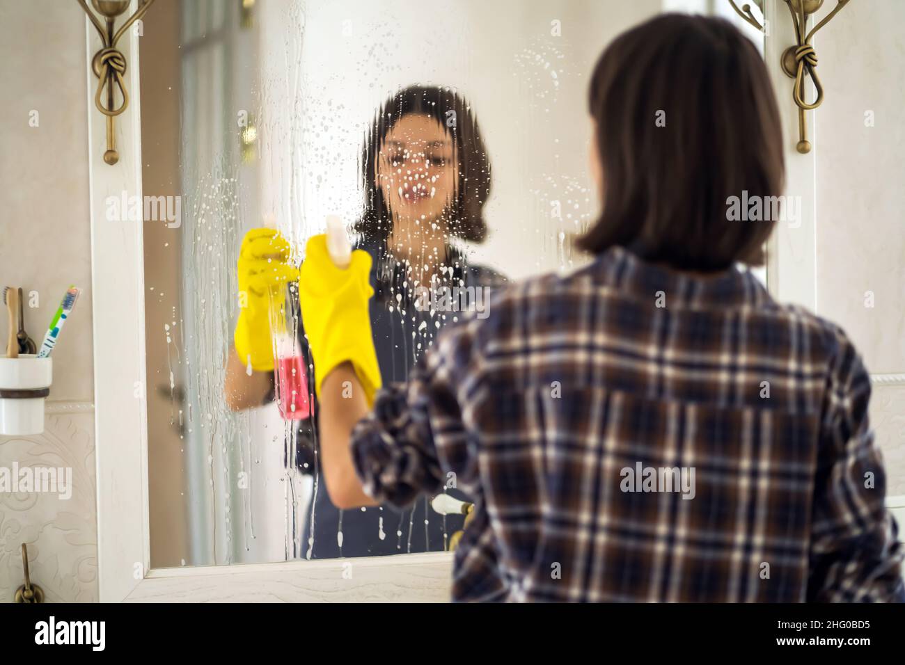 Young woman is washing mirror in the bathrom Stock Photo - Alamy
