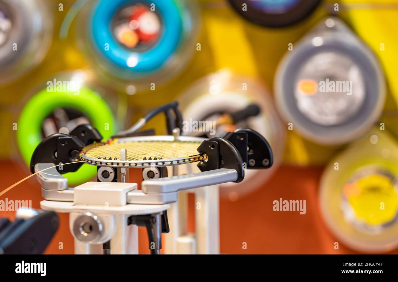 manual stringing of a badminton racket in service Stock Photo - Alamy
