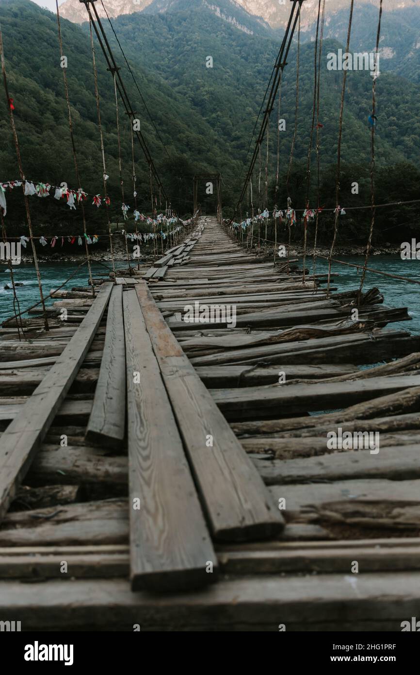 Landscape view of long wooden suspension bridge over mountains river ...