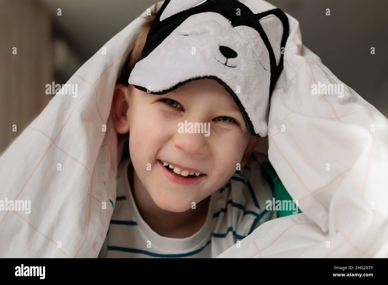 boy in a sleep mask laughing under the covers Stock Photo - Alamy